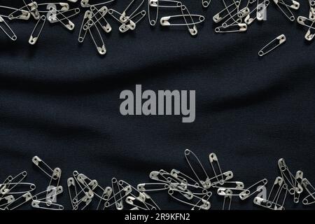 Safety pins on fabric background Stock Photo - Alamy