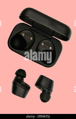 White earbuds in open case on wooden surface. Minimalist design with ...