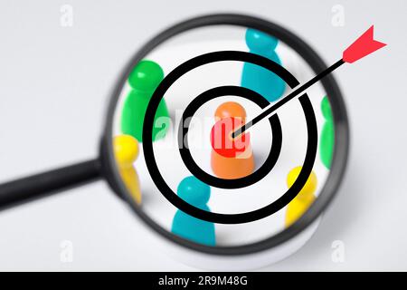 Arrow aiming to pawn, view through magnifying glass with target. White ...