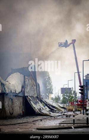 ROTTERDAM - The fire brigade extinguishes a large fire in a shed on ...