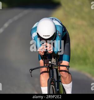 Male time trialist competing in an evening race on a sporting course at ...