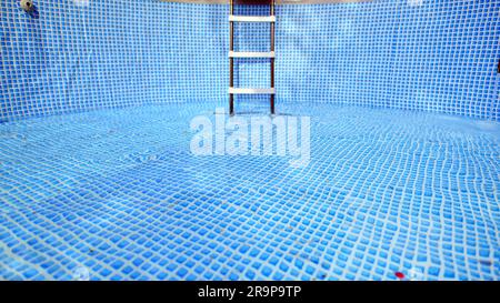 Water flowing from the hose into the pool filling. The inside of the ...