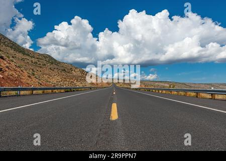 Two lane road in the arid Sierra Nevada's leading to mountains against ...