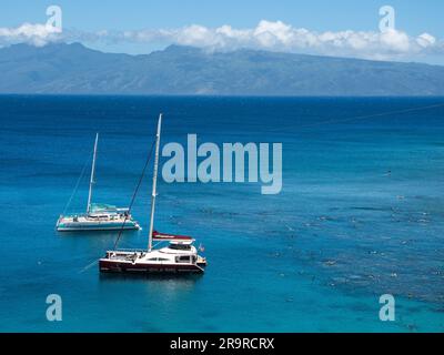 Boats are anchored in a shallow cove that is perfect for snorkeling ...