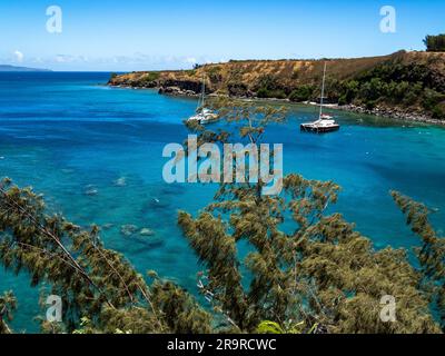 Boats are anchored in a shallow cove that is perfect for snorkeling ...