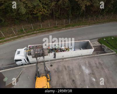 Waste loading operation, loader dumping trash in a truck on a site for ...