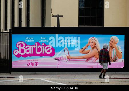 Pedestrian walks by an advertisement for the movie Barbie starring Ryan ...
