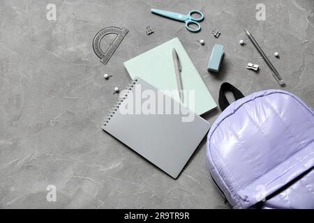 Notebooks and pens on lilac background Stock Photo - Alamy