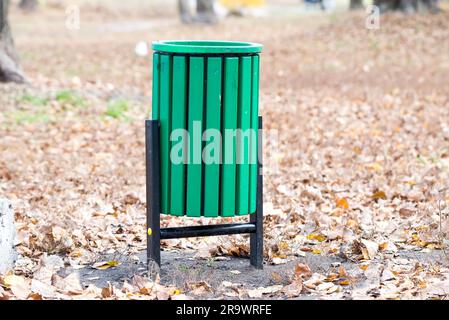 New green trash bin in the park in autumn Stock Photo - Alamy