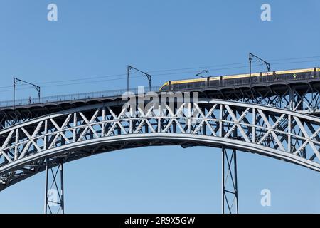 Metro do Porto train crossing the Ponte D. Luis I truss arch bridge ...