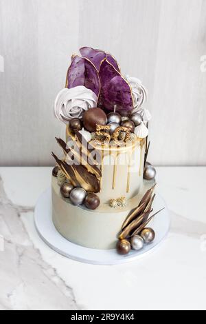 Elegant tall two-layered grey and golden cake for a man's anniversary ...