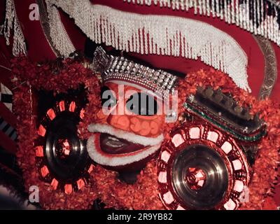 closeup of bright colored and decorated theyyam, a traditional artform ...