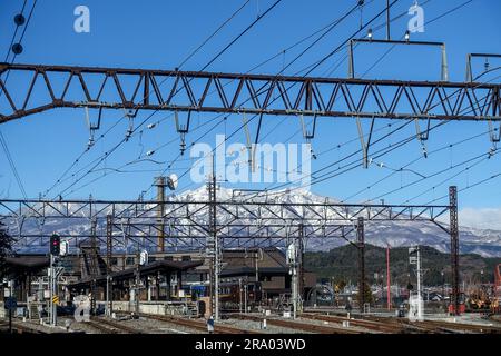 Nikko train station, rails, with snowy Japanese Alps in the backgound ...
