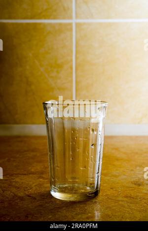 Empty glass with water drops in the kitchen Stock Photo - Alamy