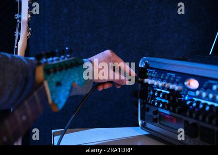 Musician connecting his electric guitar to a mixing console Stock Photo ...
