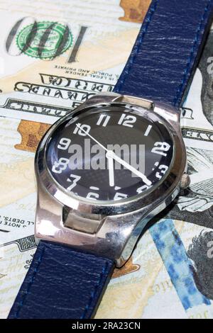 Blue wrist watch on dollars close up Stock Photo - Alamy