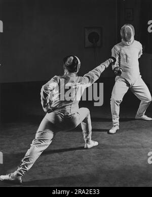Two athletes dressed in fencing attire having a match Stock Photo - Alamy