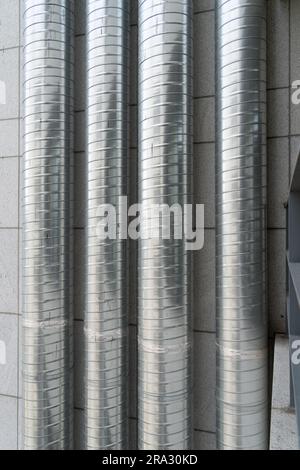 Ventilation tubes that go up to the roof on the outer wall of a high ...