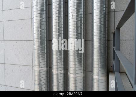 Ventilation tubes that go up to the roof on the outer wall of a high ...