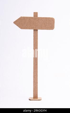 A brown cardboard cutout shaped like a sign on a pole isolated on a ...