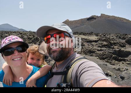 Family taking a selfie while hiking between volcanoes. Lanzarote Stock Photo - Alamy