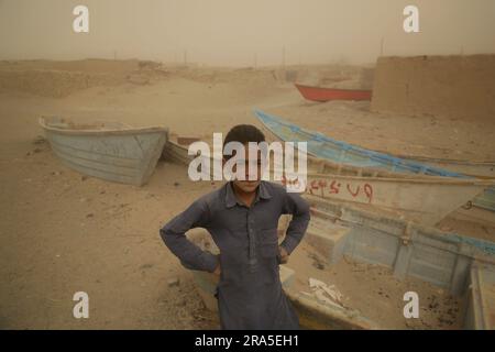 FILED - 21 June 2023, Iran, Zabol: A child's face reflected in a bucket ...