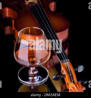 Snifter glass of cognac and violin Stock Photo - Alamy