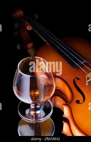 Snifter glass of cognac and violin Stock Photo - Alamy