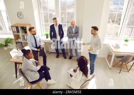 company employees discussing standing in the office Stock Photo - Alamy