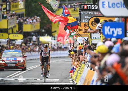 Cyclists entering the finish line lagging behind in a stage of the 2023 ...