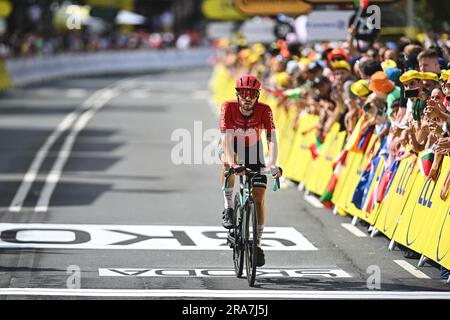 Cyclists entering the finish line lagging behind in a stage of the 2023 ...