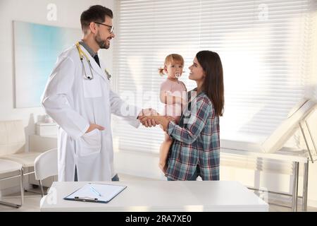 Mother and her cute baby having appointment with pediatrician in clinic ...
