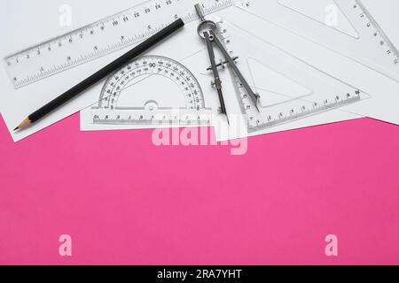 Different rulers, pencil, compass and paper sheets on turquoise ...