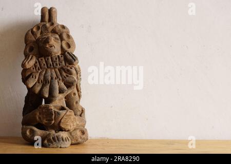 Mayan god clay statues on wooden and white background with copy text ...