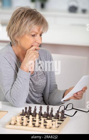 Nurse playing chess with a mature woman after a healthcare consultation ...