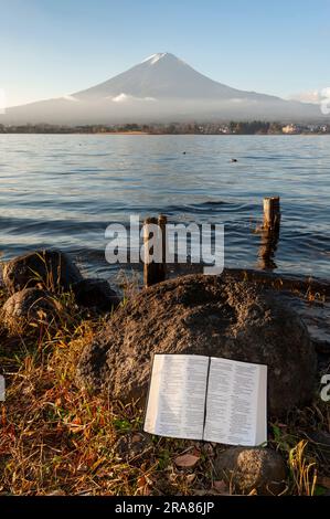 Holy Bible leaning against a rock on the shore of Lake Kawaguchi with ...
