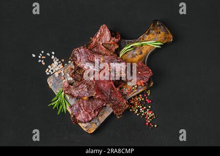 A Pile of Black Pepper Beef Jerky on a Rustic Wooden Table Stock Photo ...