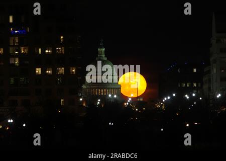 A full moon rises behind the U.S. Marine Corps War Memorial in ...