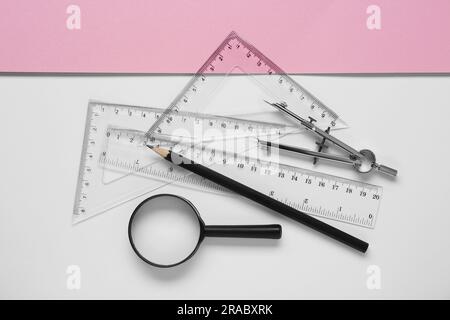 Different rulers, pencil, compass and paper sheets on turquoise ...