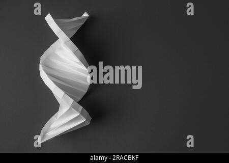 Paper model of DNA molecular chain on black background, top view. Space ...