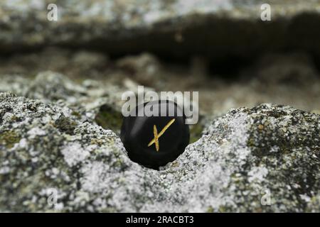 Black rune Nauthiz on stone outdoors. Old Germanic alphabet Stock Photo ...