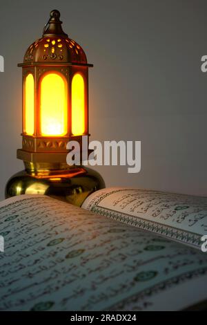 Quran and Arabic lamp with bright light with dark background Stock ...