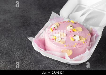 Box with tasty bento cake, gifts and hearts isolated on white ...