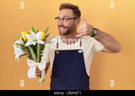 Mature male florist communicating on cell phone Stock Photo - Alamy