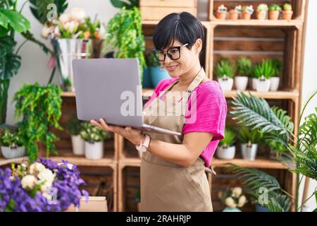 Middle age chinese woman florist smiling confident writing on notebook ...