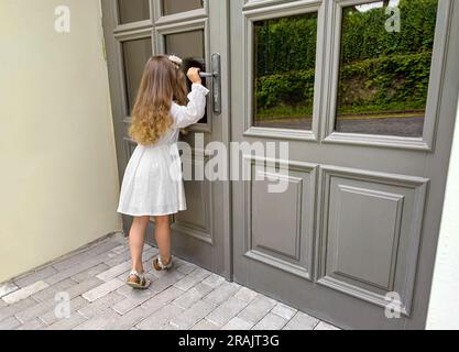 Child peeking through the door window Stock Photo - Alamy