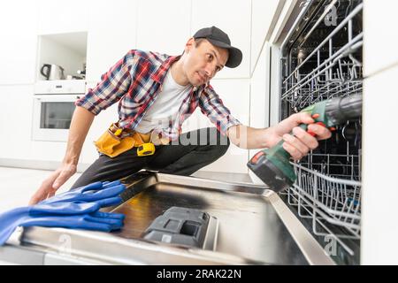 One repairman fixing malfunctioning kitchen dishwasher problem Stock ...