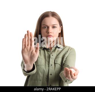 Young female junkie with drugs showing STOP gesture on white background ...