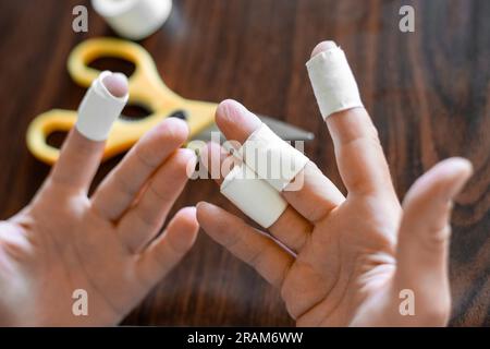 Women's hands with bandaged fingers. Safety precautions when working ...