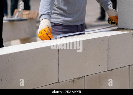 The bricklayer works to measure. Measuring with a meter Stock Photo - Alamy